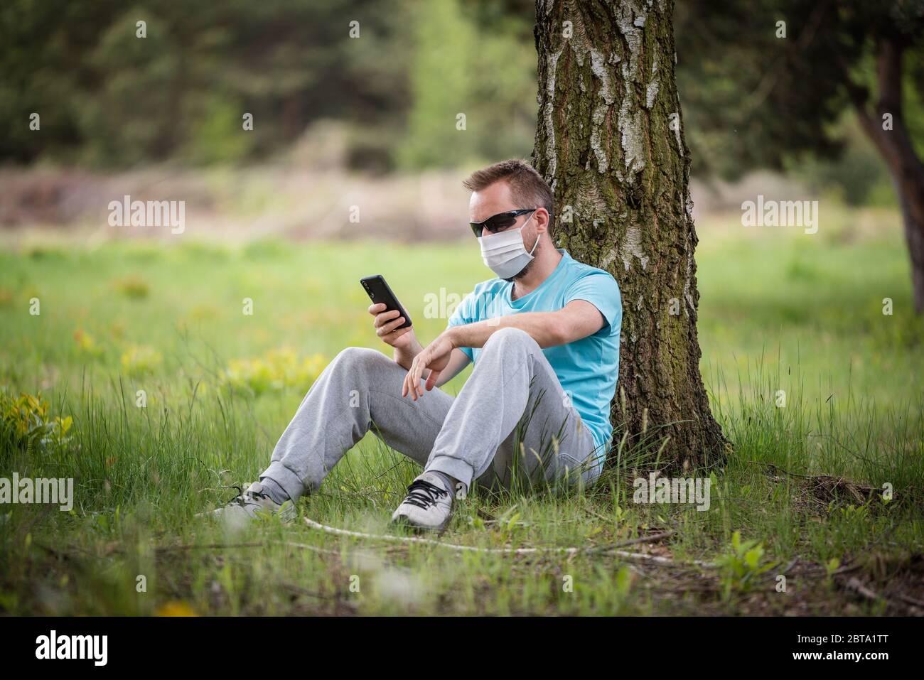 Man wearing a mask with smartphone Stock Photo - Alamy