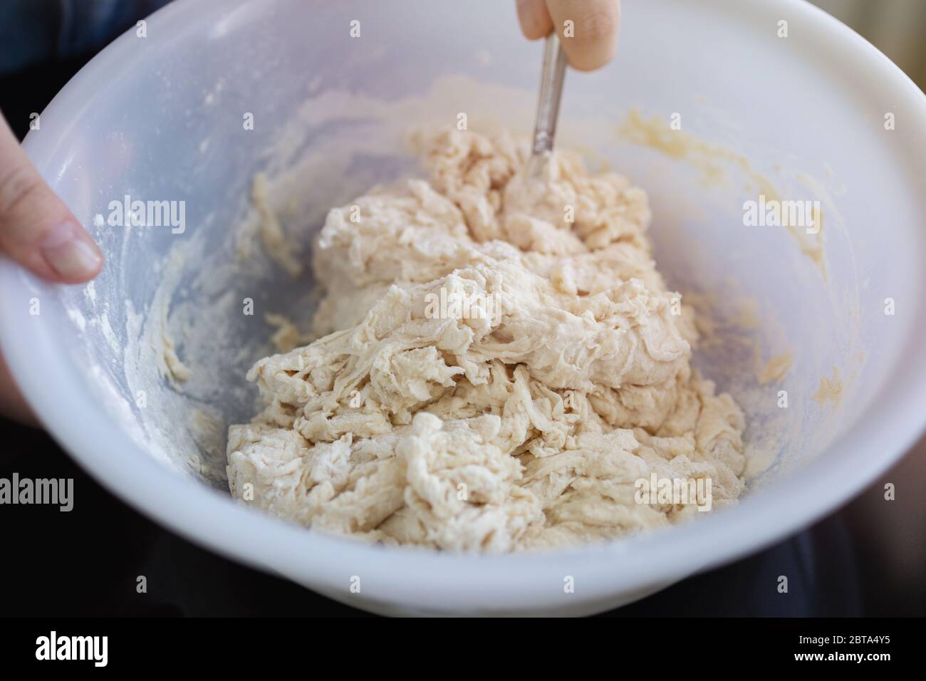 Close up background of kneading dough in bowl for bread, pasta or pizza ...