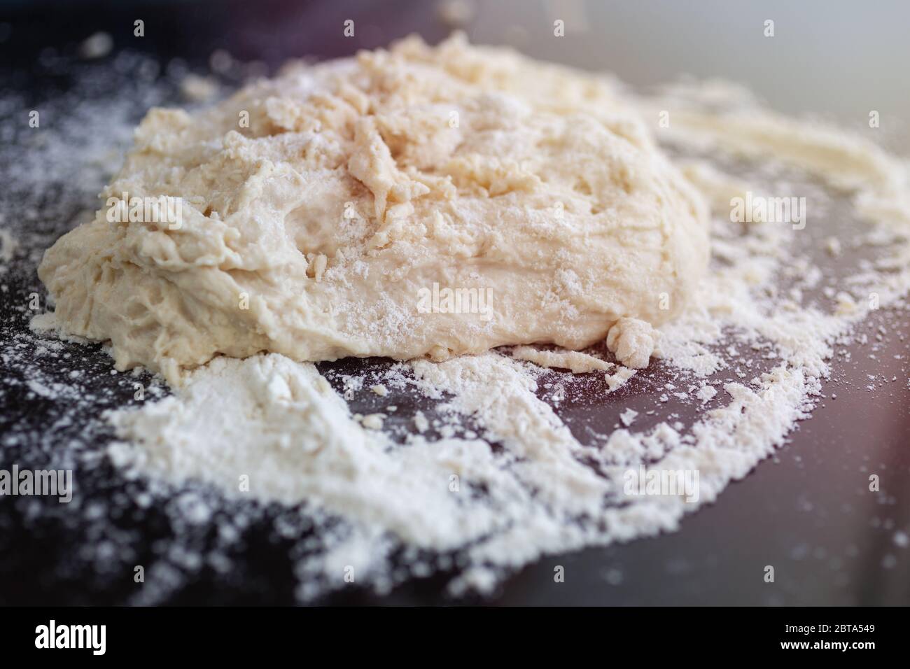 Close up background of kneaded dough for bread, pasta or pizza on black ...