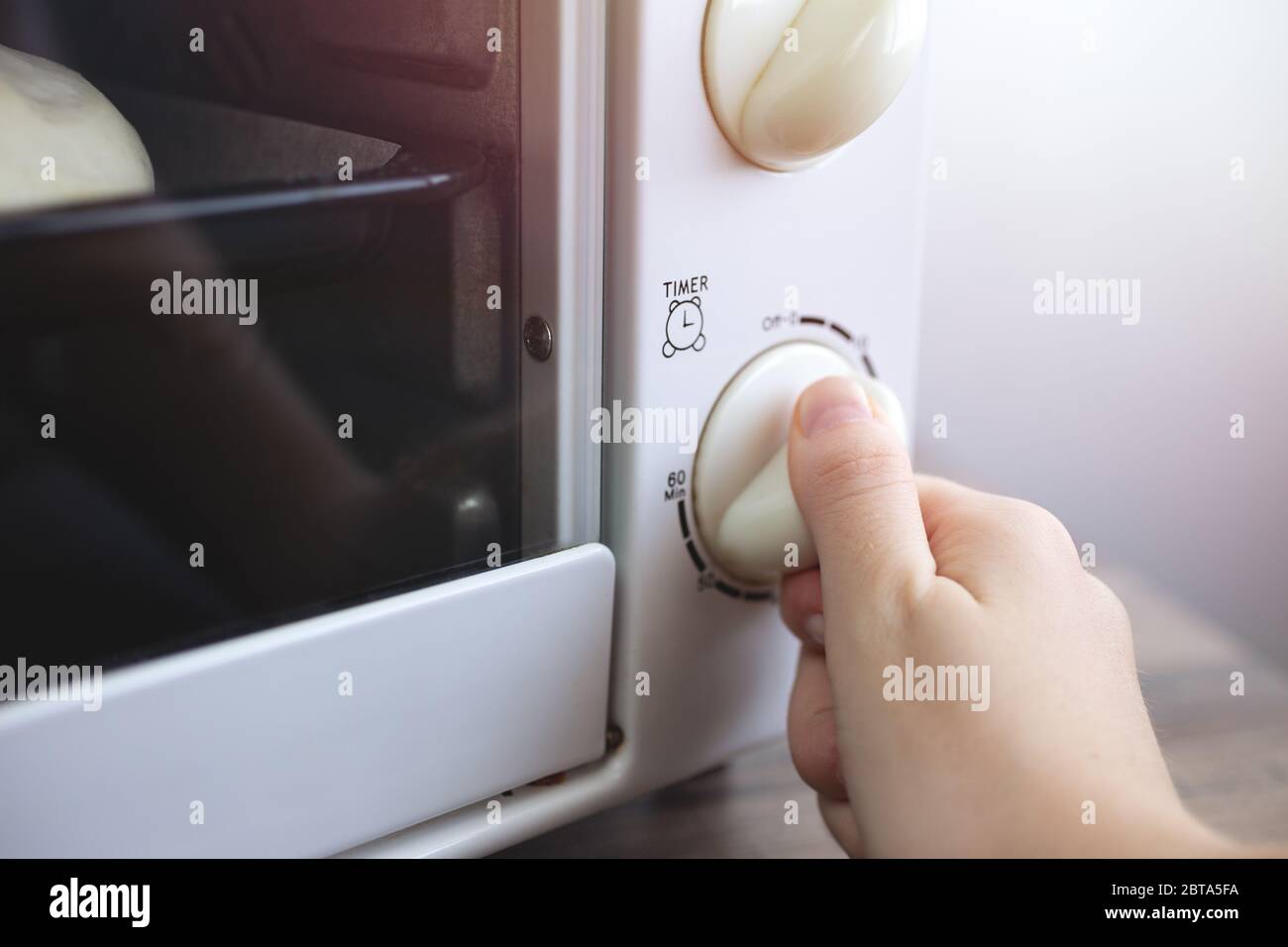 Close up background of hand turning setting timer on microwave oven ...