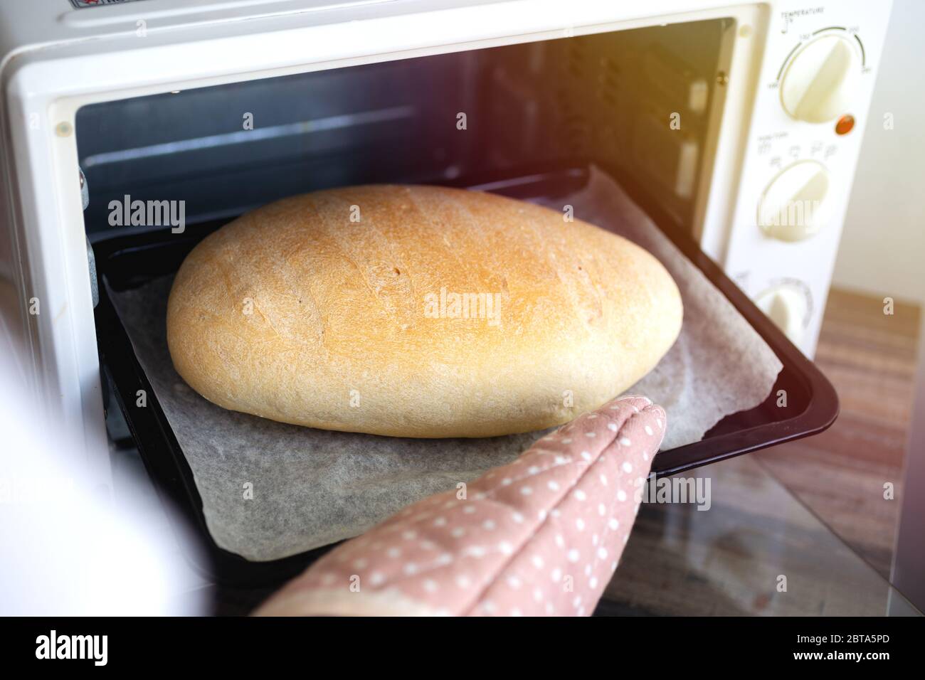 Taking bread out of the oven hi-res stock photography and images - Alamy