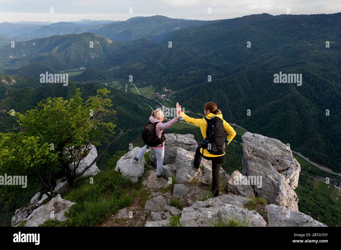 Two women giving high-five in mountain landscape Stock Photo - Alamy