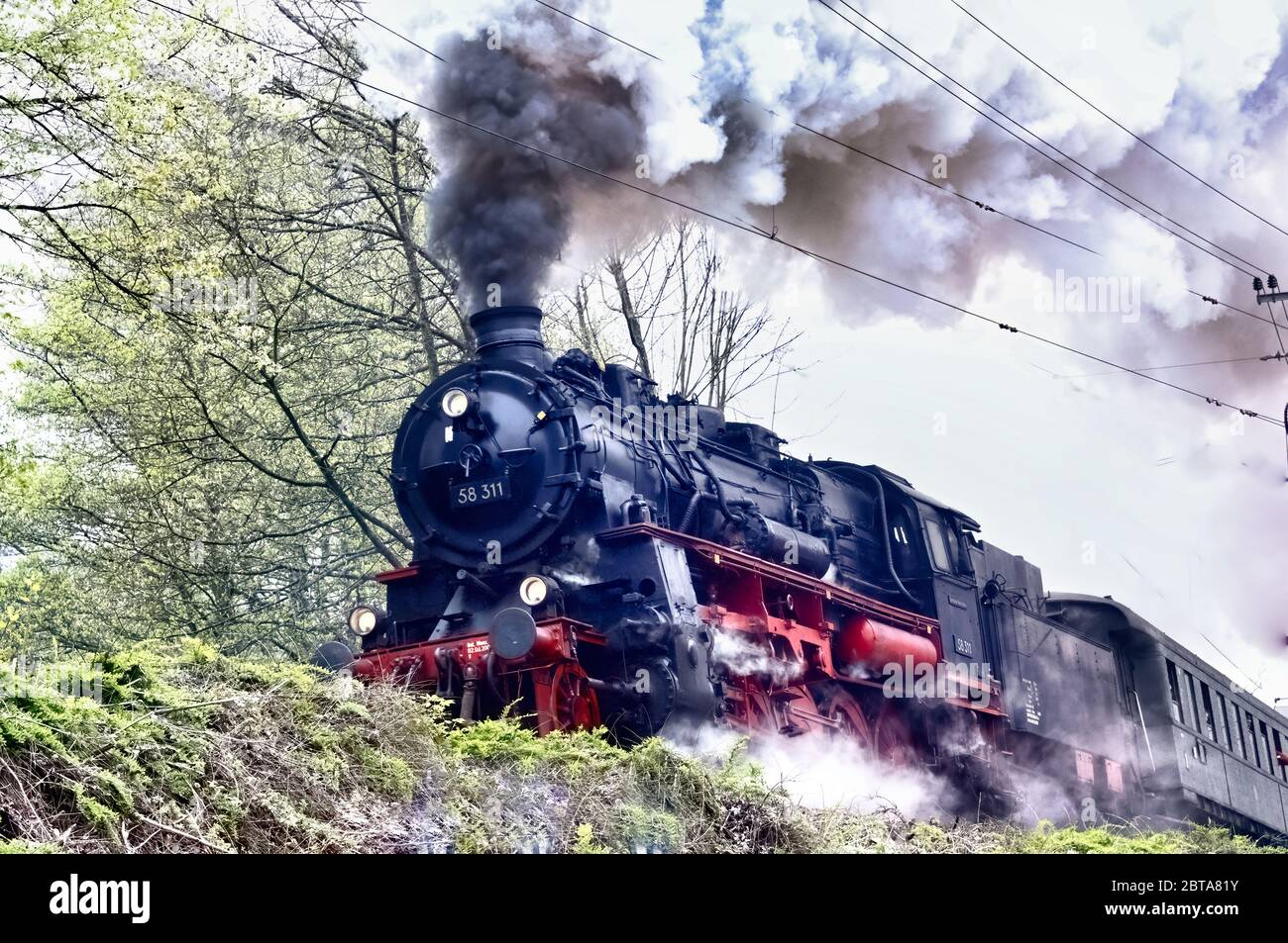 Historic train with steam lok, heavy smoke from the chimney, worm's eye ...