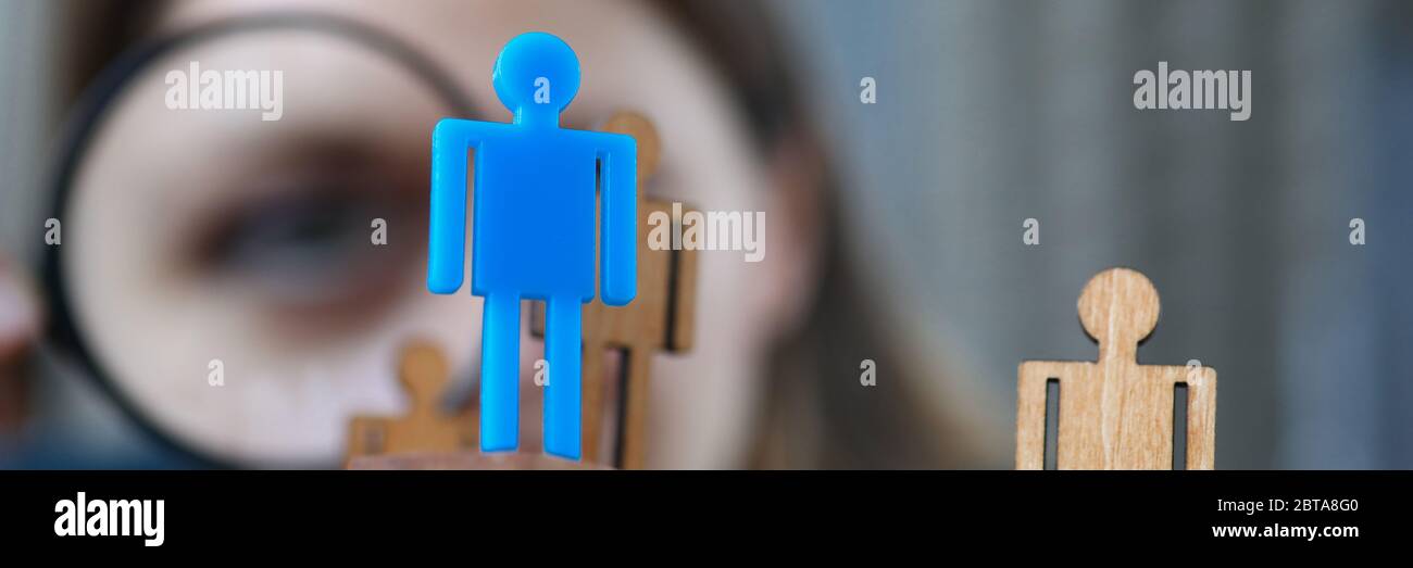 Woman looking through magnifier at figures men Stock Photo - Alamy