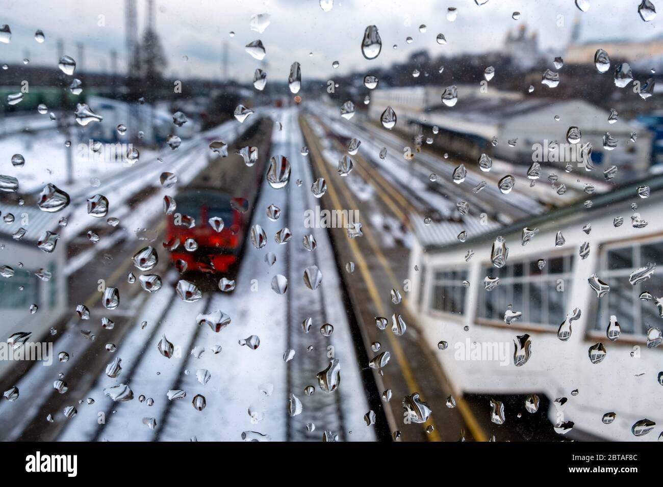 Raindrops on window and background is a train and railway tracks. Close ...