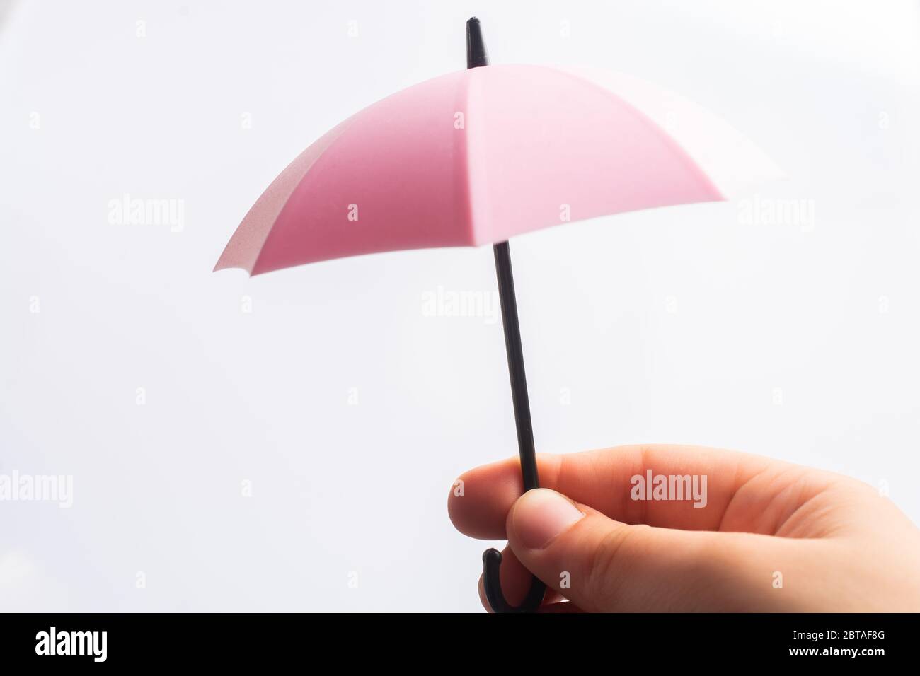 Hand with small tiny umbrella in hand Stock Photo - Alamy