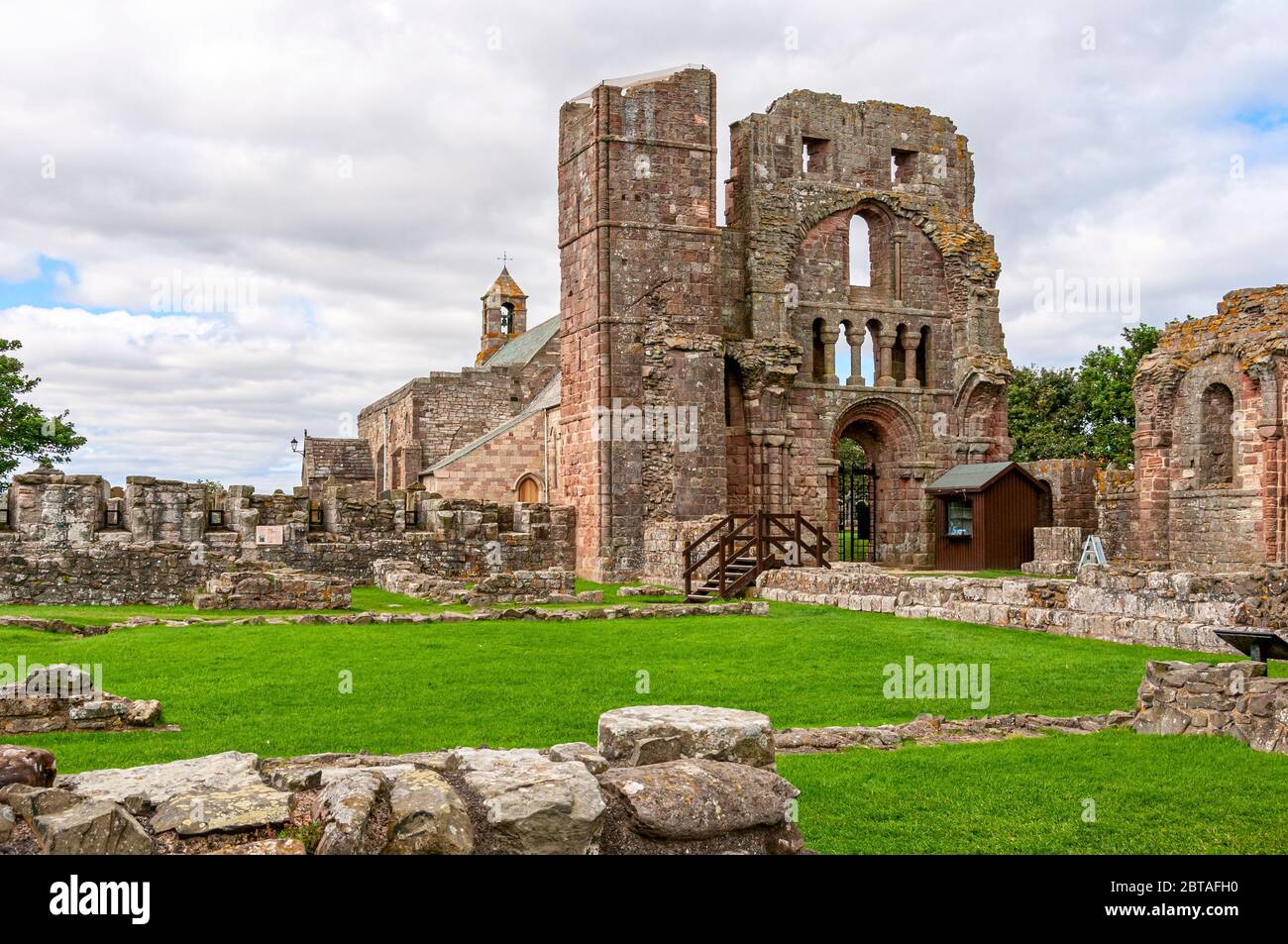 The imposing fortified west doorway of the dark red sandstone church of ...