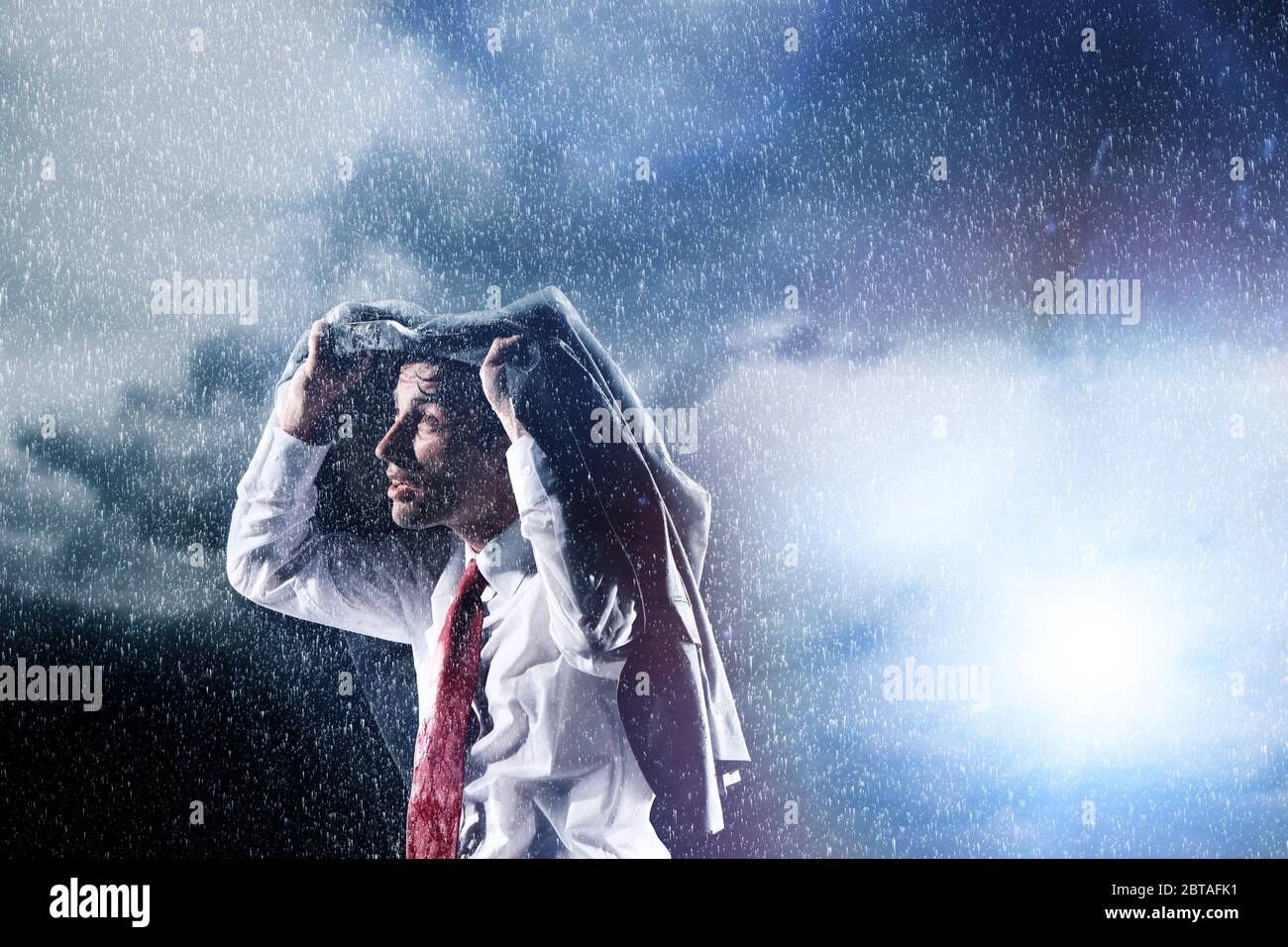 Businessman Caught in heavy Rain hiding under his jacket Stock Photo ...