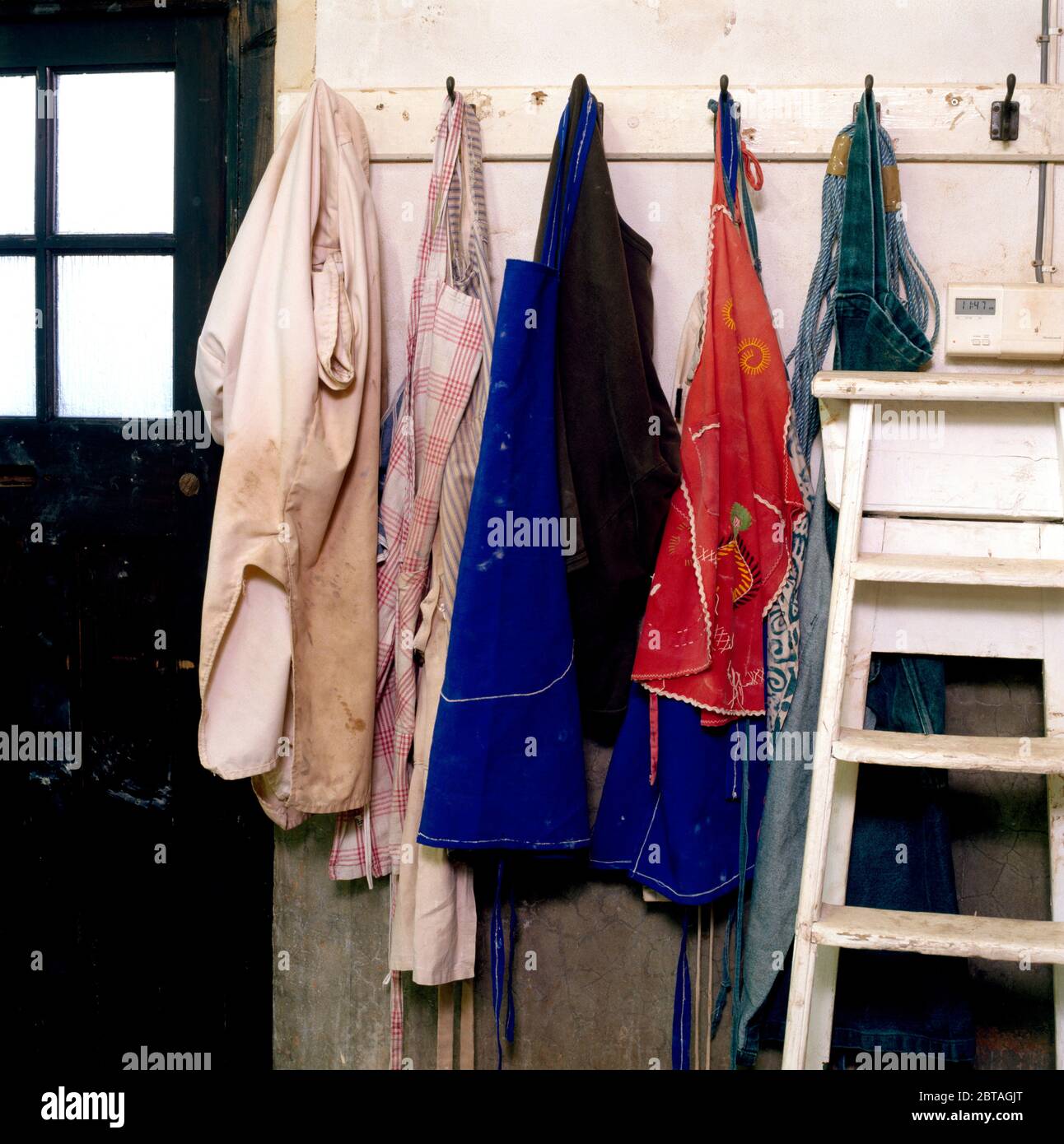 Aprons hanging on peg board Stock Photo - Alamy