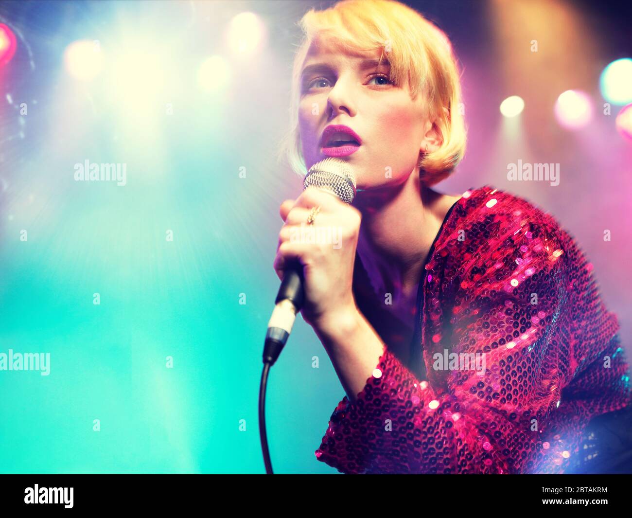 Young female rockstar Singing in Concert Stock Photo - Alamy