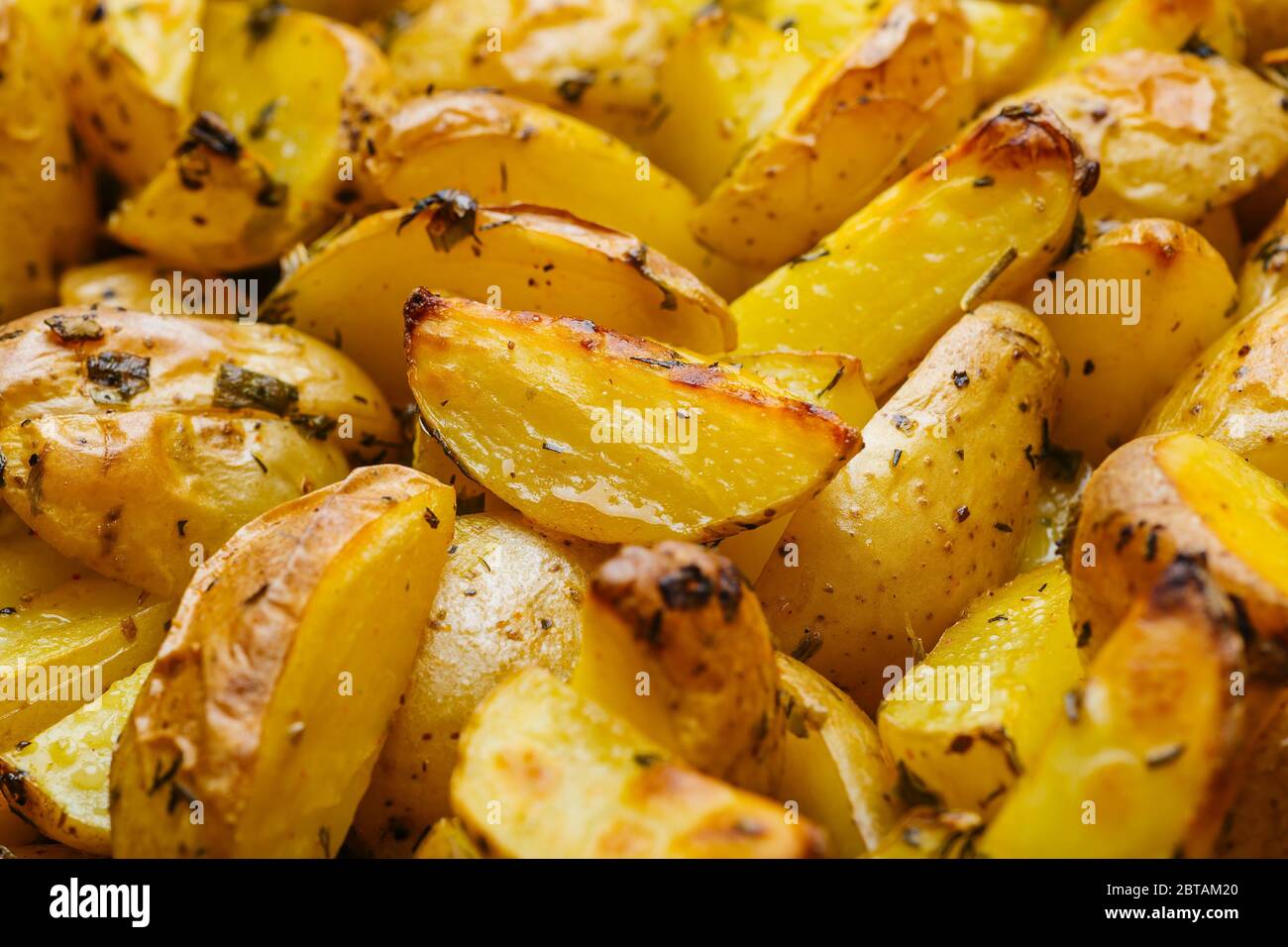 Roasted potatoes in a rustic backgarund. Slices of rustic fried ...
