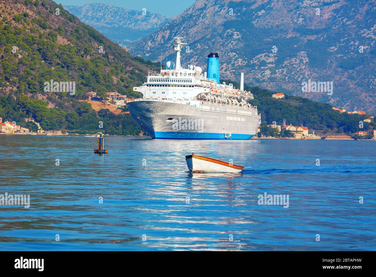 small wooden boat in front of cruise liner Stock Photo - Alamy