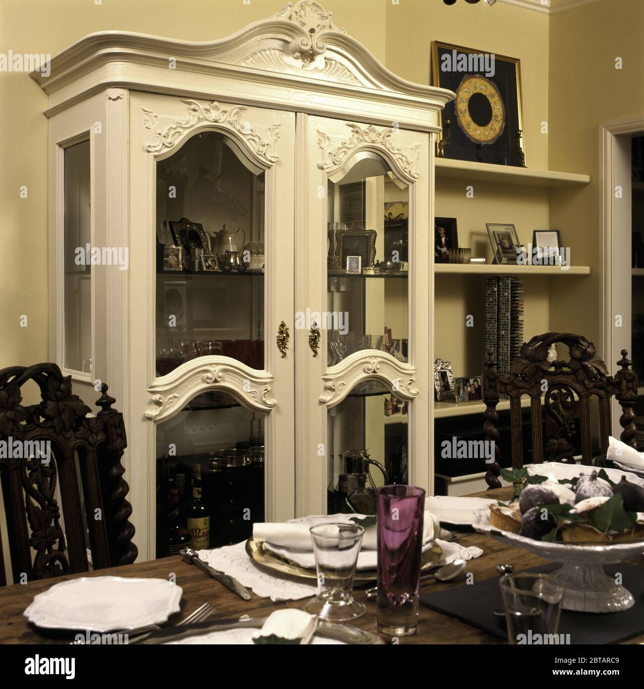 Glass front cupboard in old fashioned dining room Stock Photo - Alamy