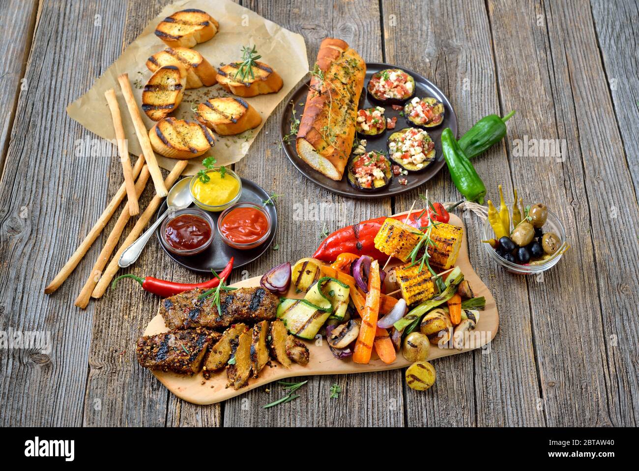 Grilled vegan seitan steaks with mixed vegetables, spicy sauces and ...
