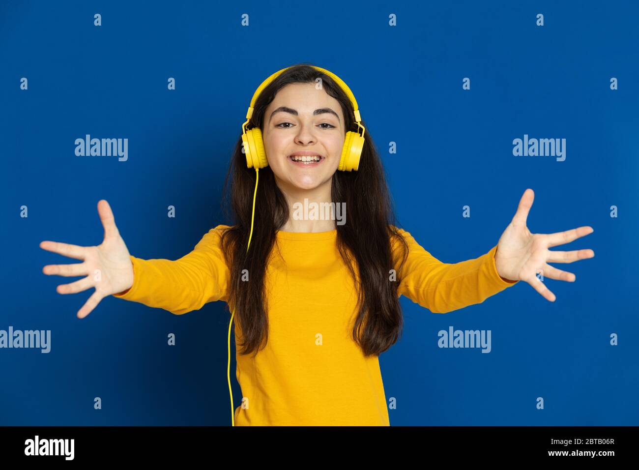 Brunette young girl wearing yellow jersey on a blue background Stock ...