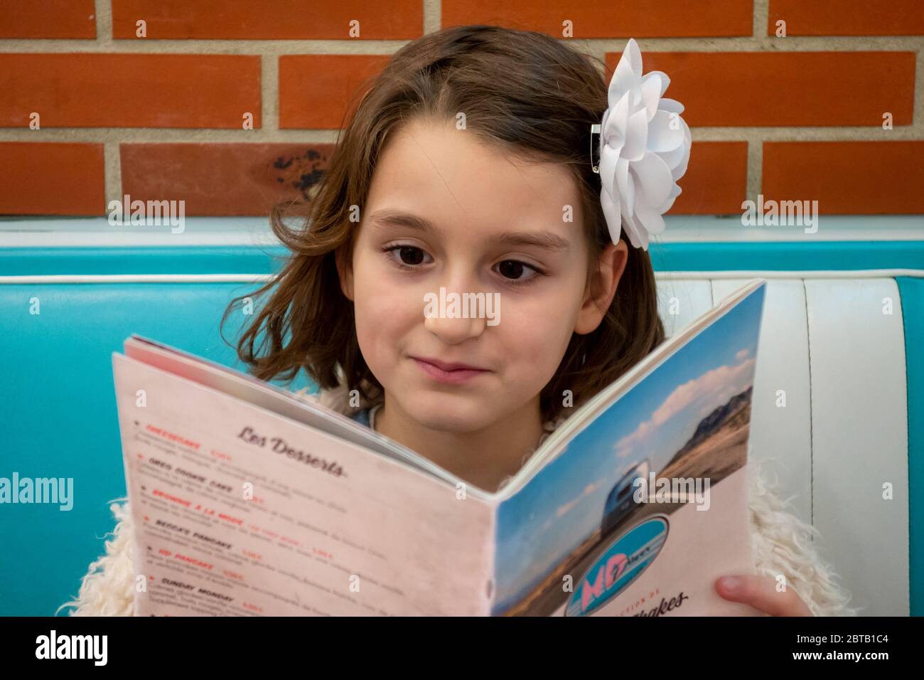 Young girl reading the menu in an american restaurant (HD Diner in ...
