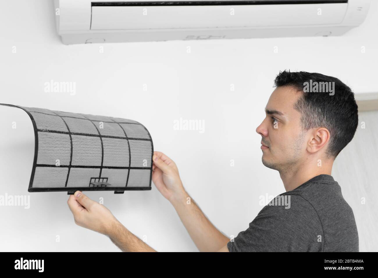 The guy cleans the filter of the home air conditioner from dust. Very ...