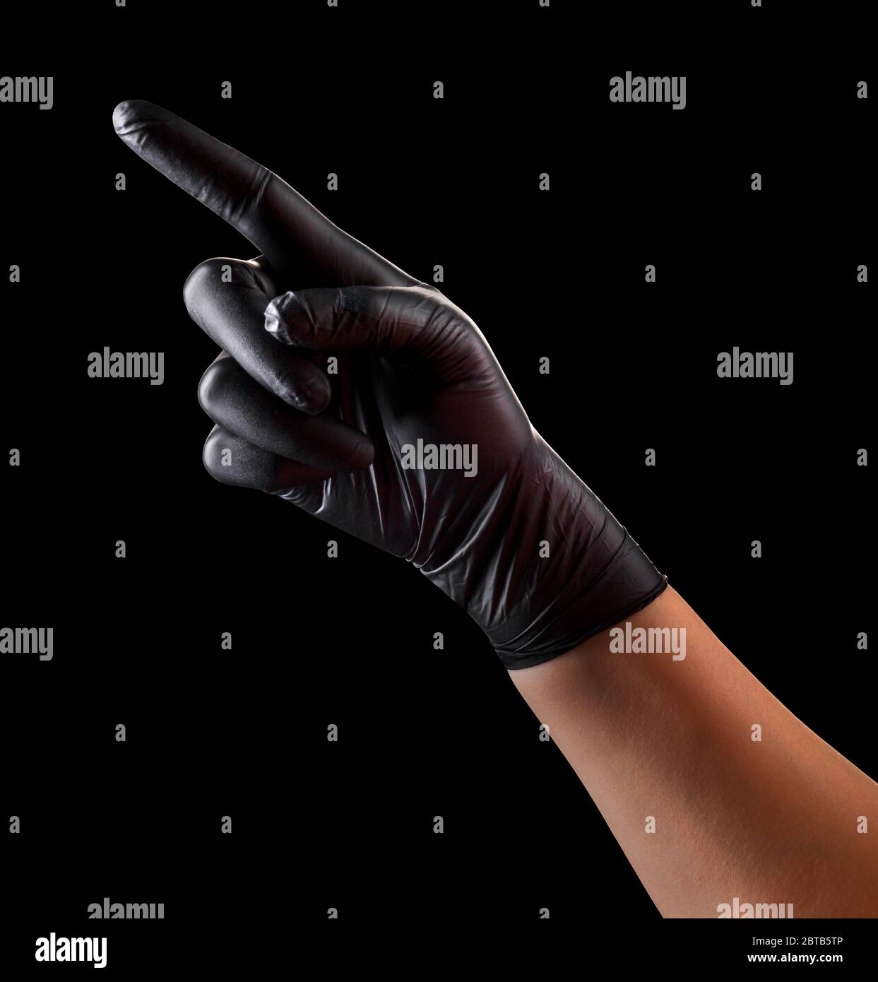 Hand in black gloves with index finger pointing or touching something ...
