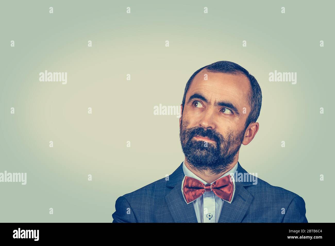 Man looking to the left at something in studio. Mixed race bearded ...