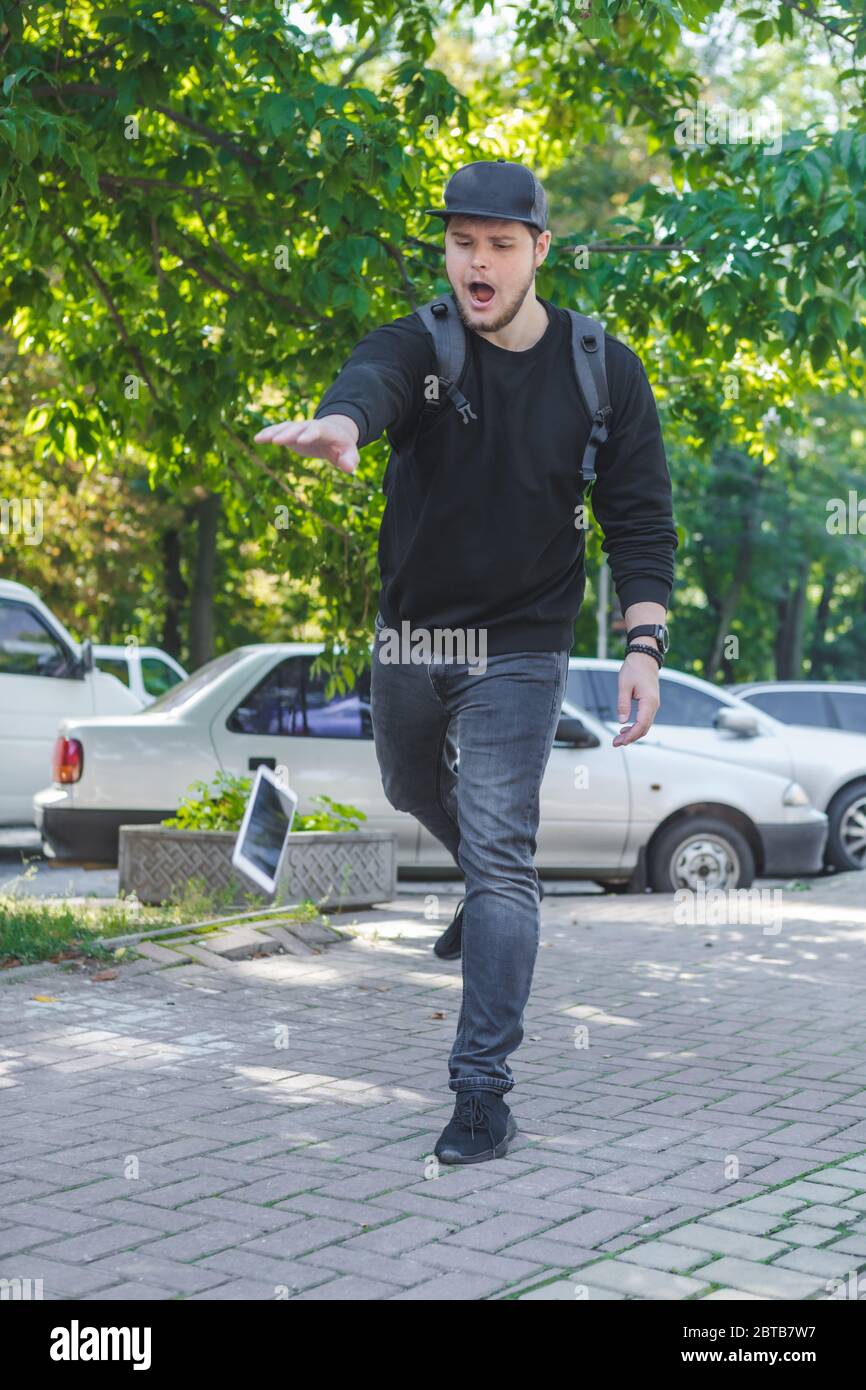 young man let down mobile phone on stone ground Stock Photo - Alamy