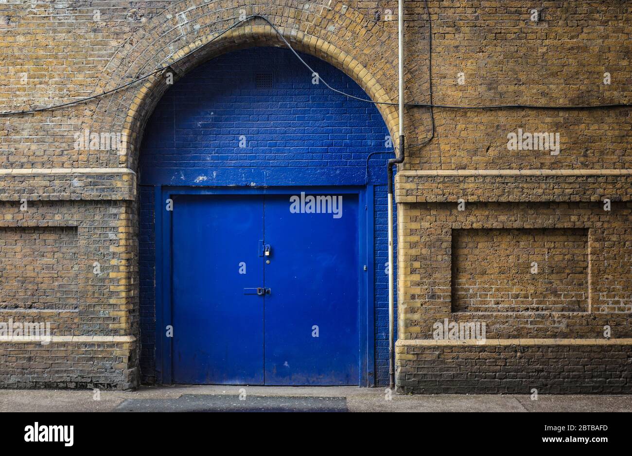 Blue door in a brick wall Stock Photo - Alamy