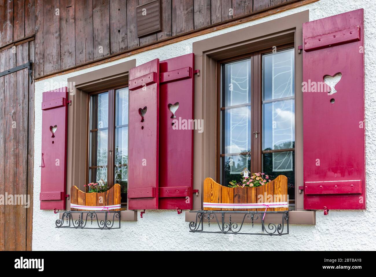 Traditional wood red windows in Switzerland with flower pots Stock ...