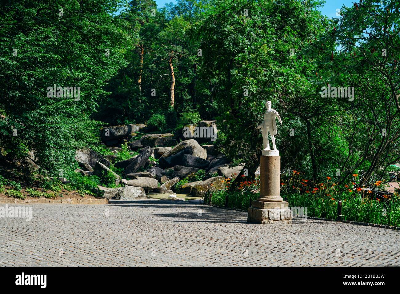 Sofia Park, Uman. Stone walkway with statues in the park. White statue ...