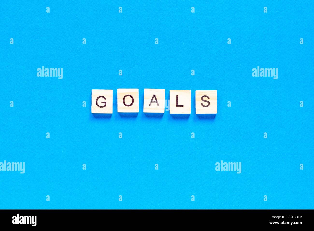 the inscription goals in wooden letters on a blue background, flat ...