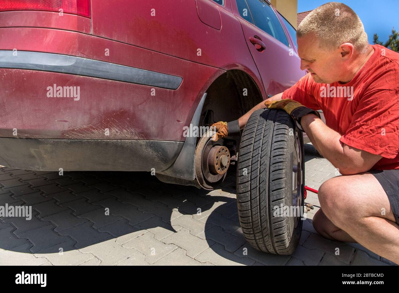 Man changing a wheel in his car. Damaged tire. Car repair on the road ...