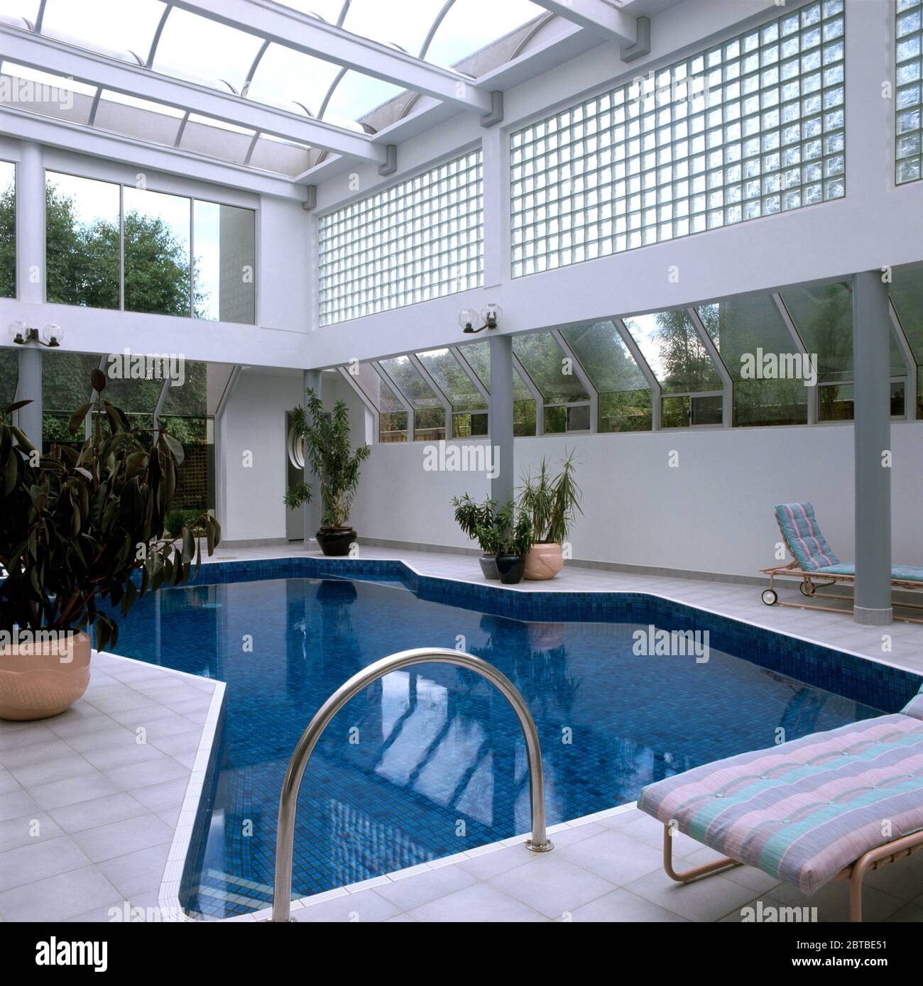 Swimming pool set in a large modern conservatory building Stock Photo ...
