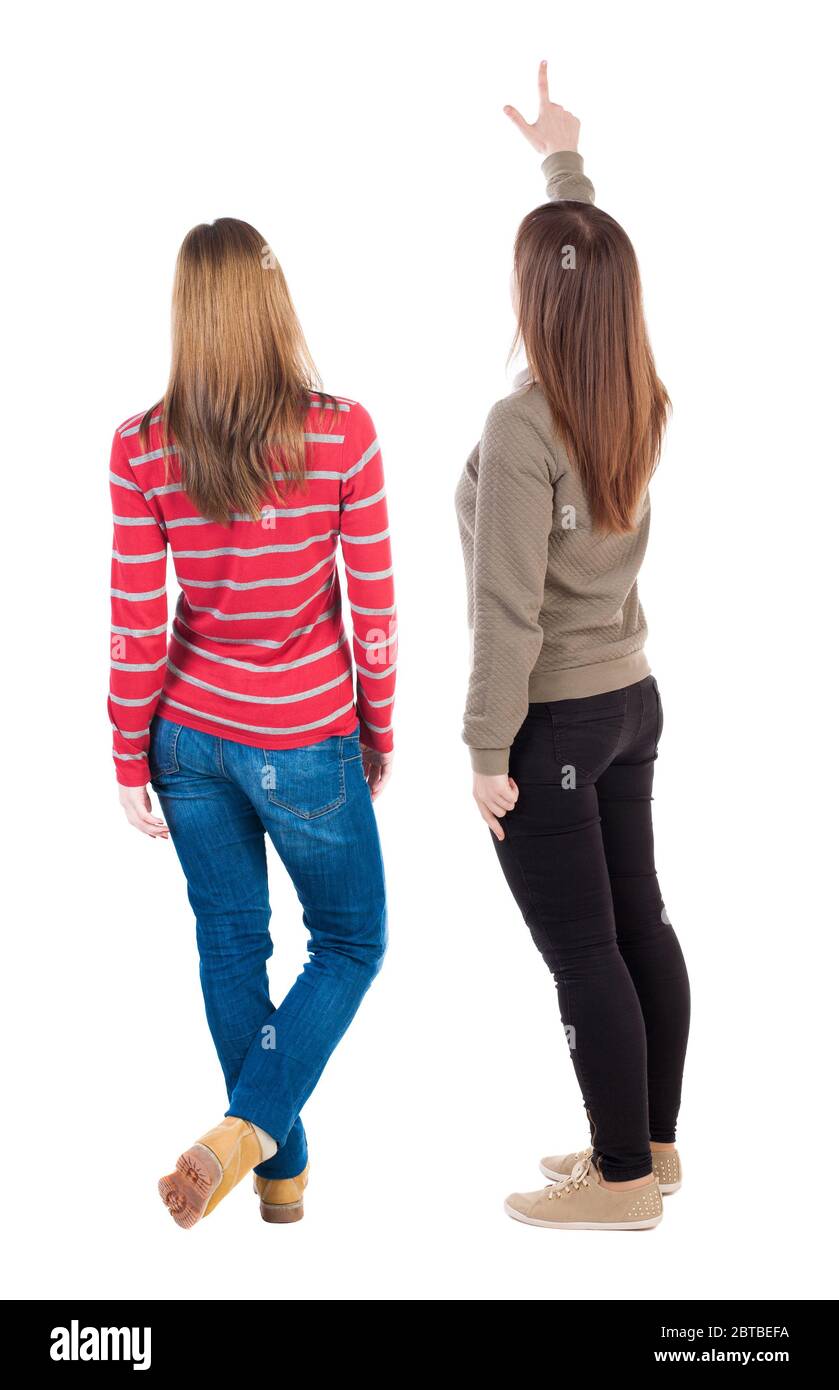 Back view of two young woman photographed on a mobile phone in sweater ...