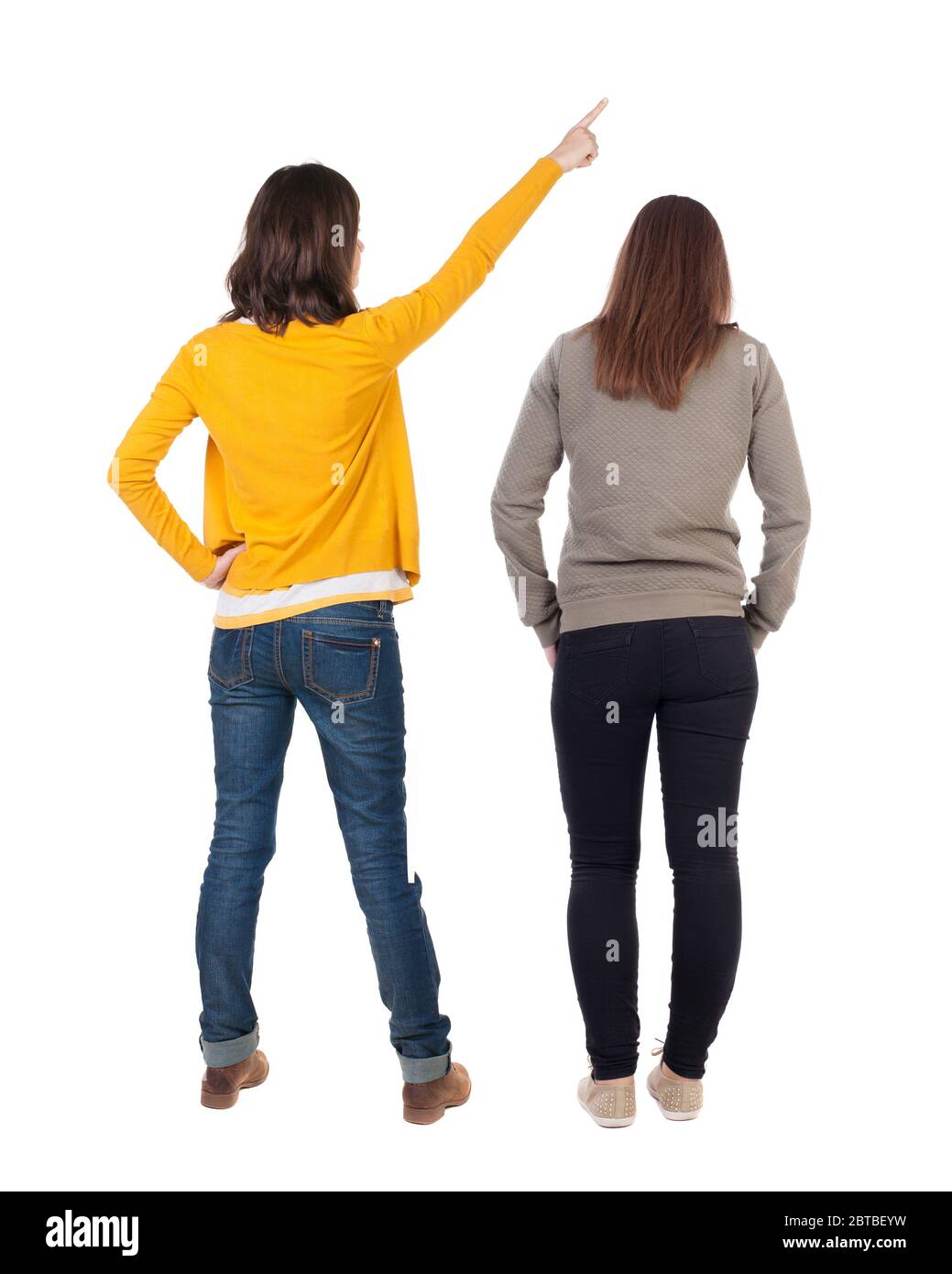 Back view of two young woman photographed on a mobile phone in sweater ...