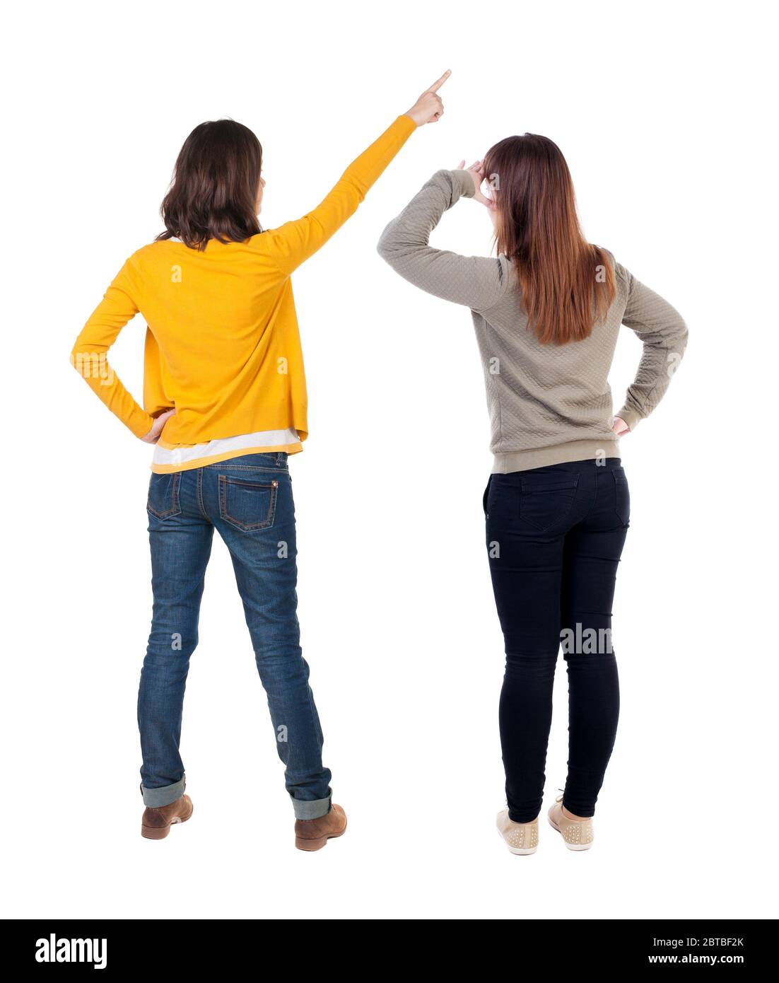 Back view of two young woman photographed on a mobile phone in sweater ...