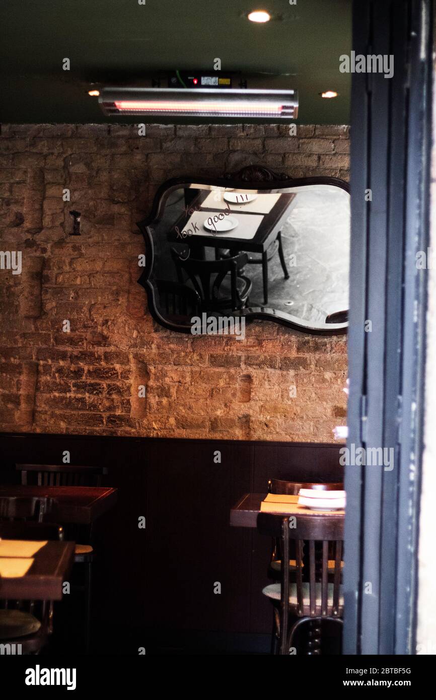 Restaurant table reflected in a mirror on a bricks wall Stock Photo - Alamy