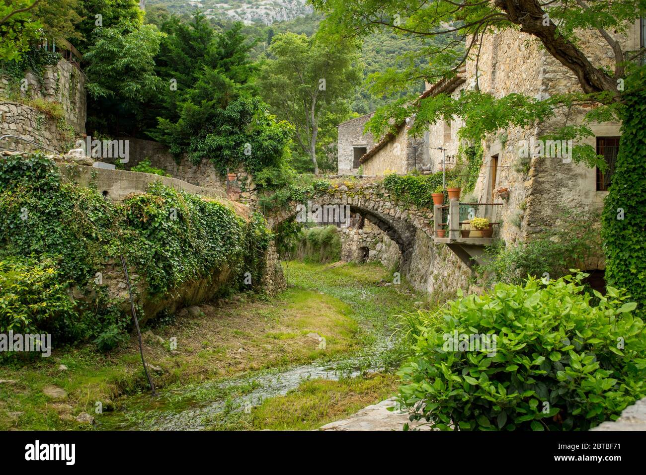 A quaint stone bridge over a creek in the medieval french village of St ...