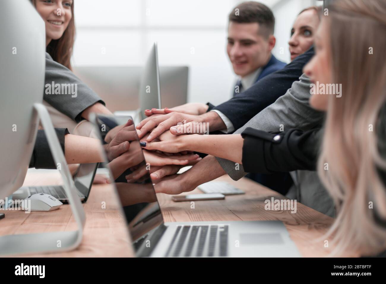 group of employees forming a stack of hands on the desktop Stock Photo ...