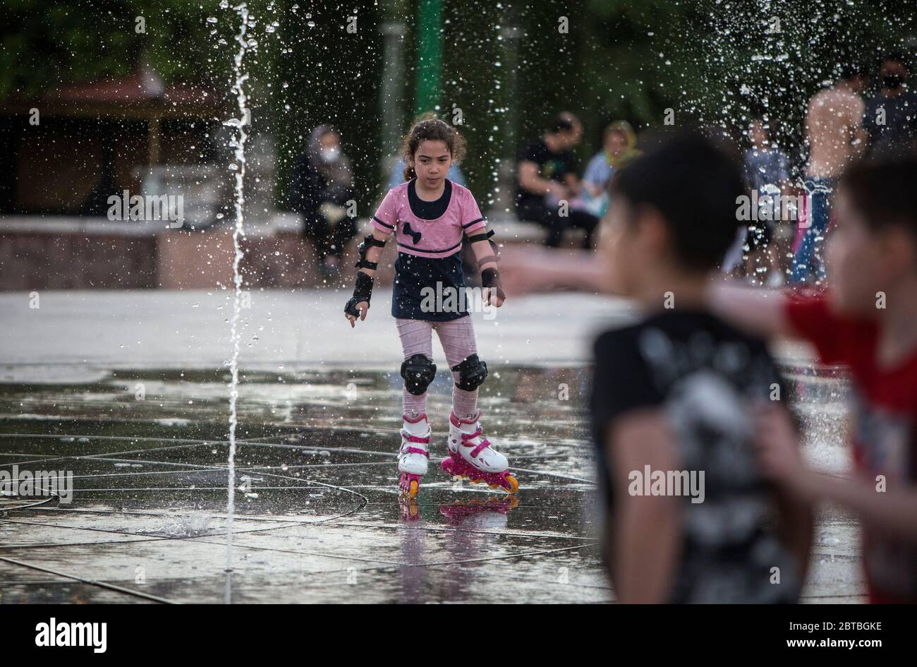 Tehran, Iran. 24th May, 2020. Children have fun at a fountain in a park ...