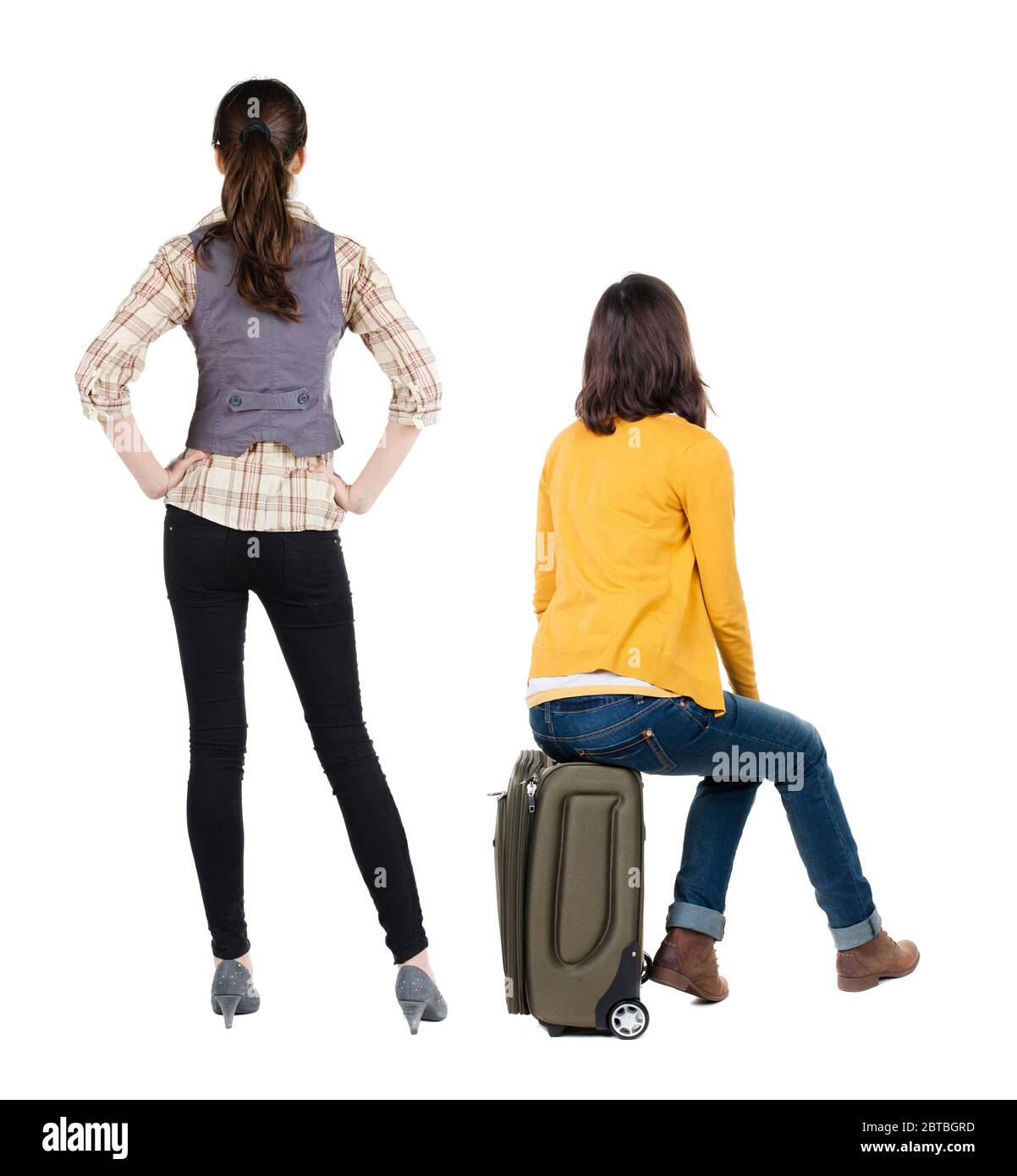 Back view of two woman in sweater traveling with suitcas. Back view ...