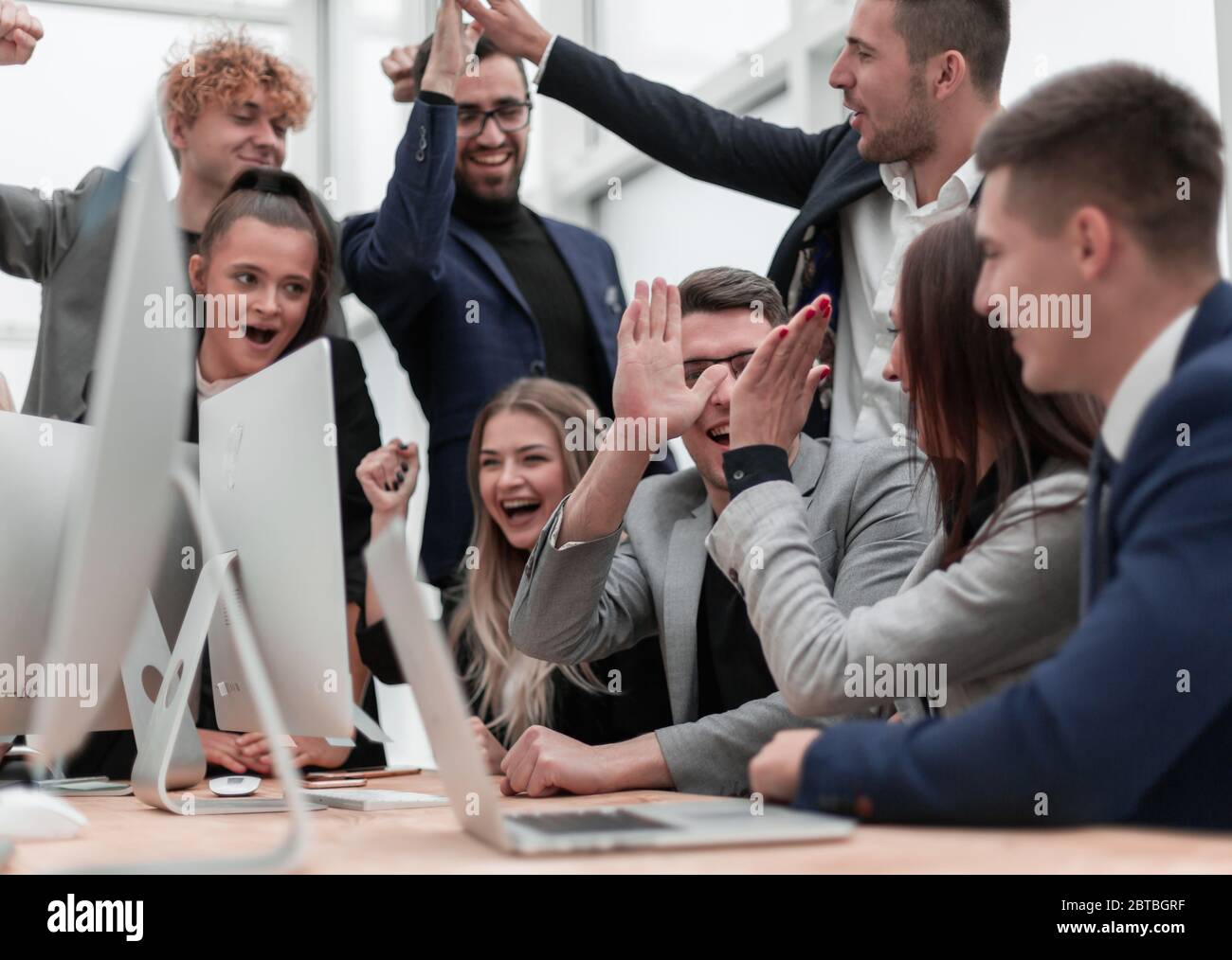 happy business team cheering near the desktop Stock Photo - Alamy