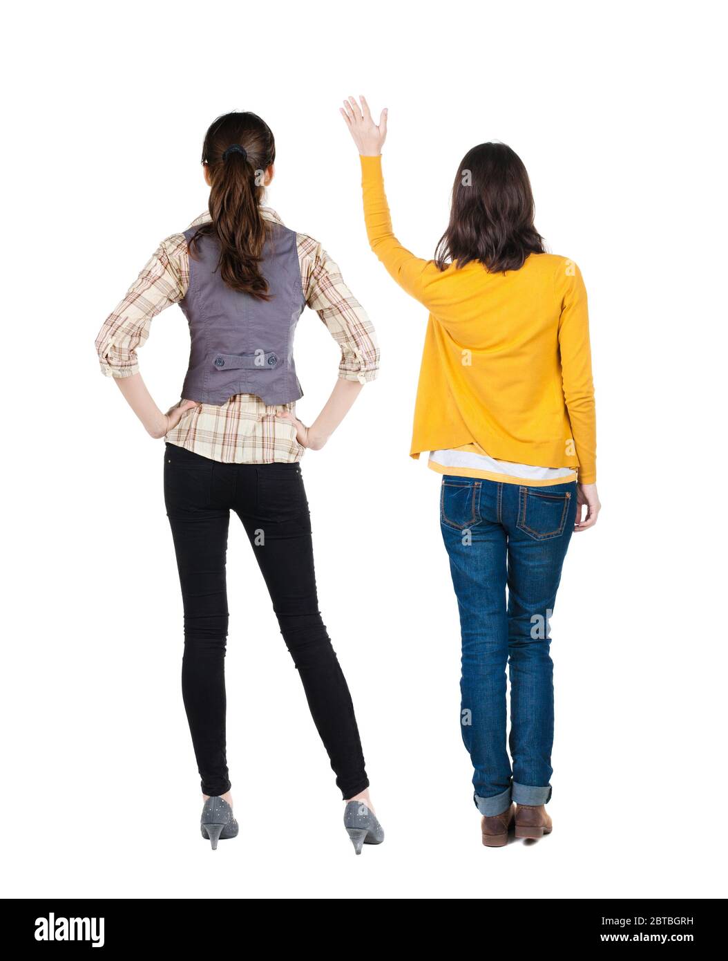 Back view of two young woman photographed on a mobile phone in sweater ...