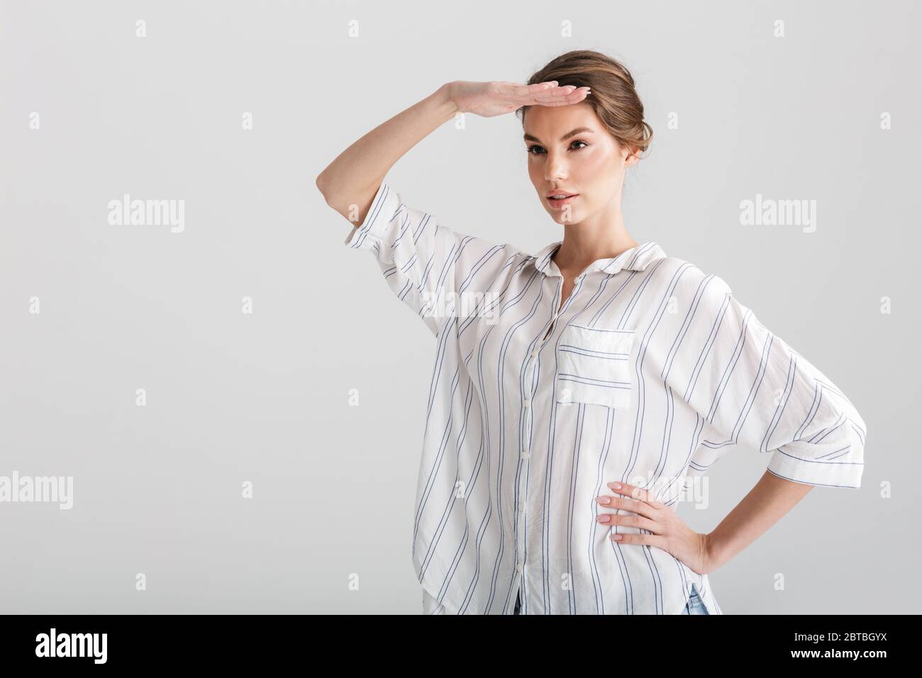 Image of focused caucasian woman looking aside with hand on her ...