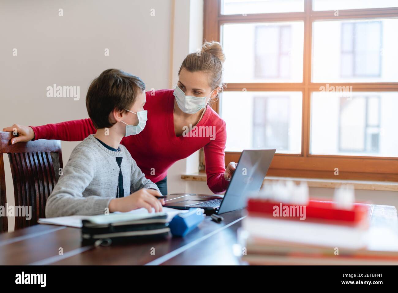 Mother and child having e-learning session with teacher during crisis ...