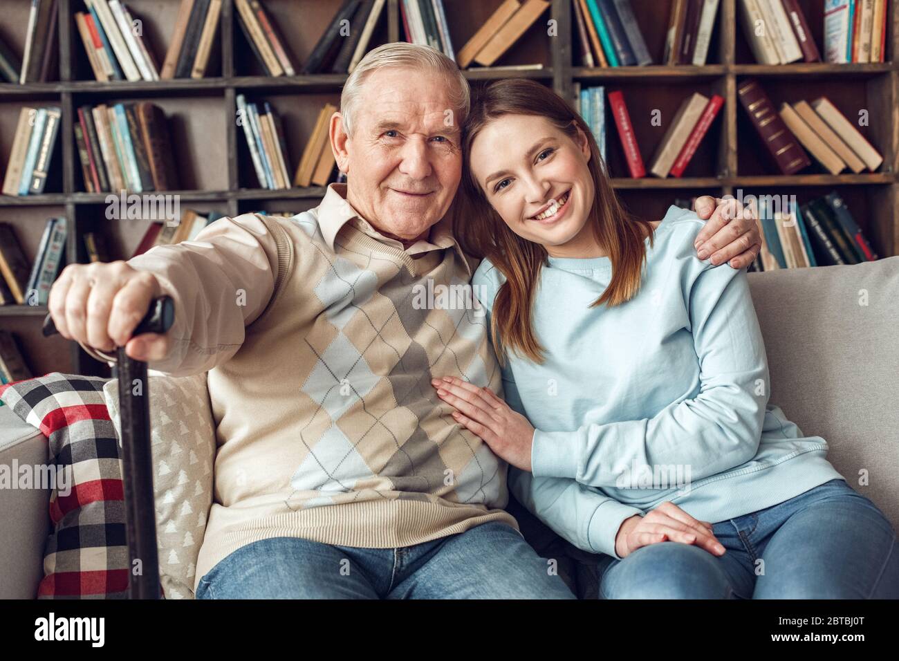 Father and daughter at home library sitting hugging smiling cheerful ...