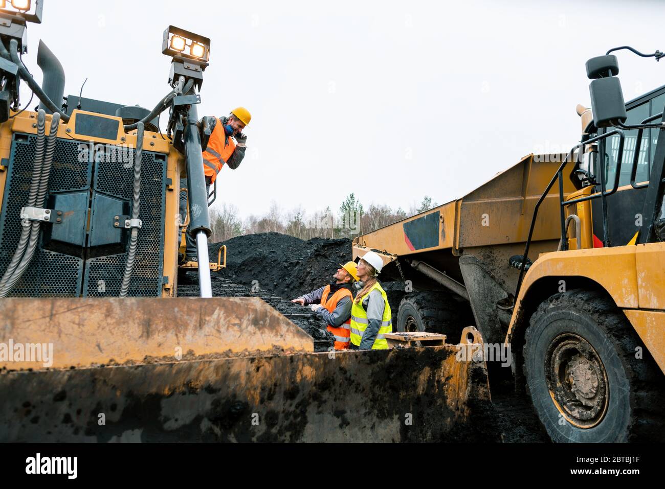 Heavy machinery and workers in pit of quarry Stock Photo - Alamy
