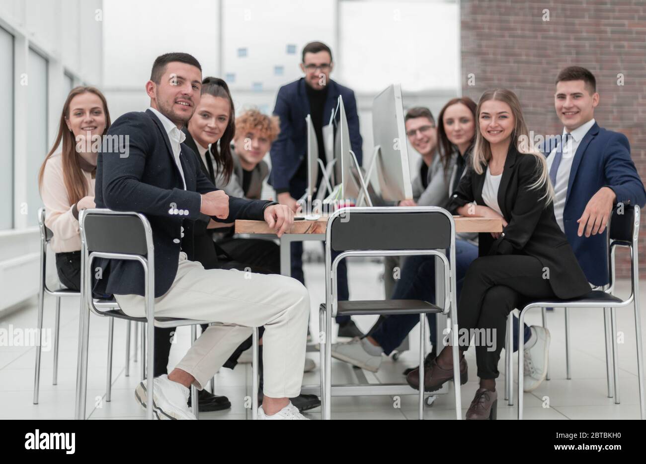 large group of employees sitting at office Desk Stock Photo - Alamy