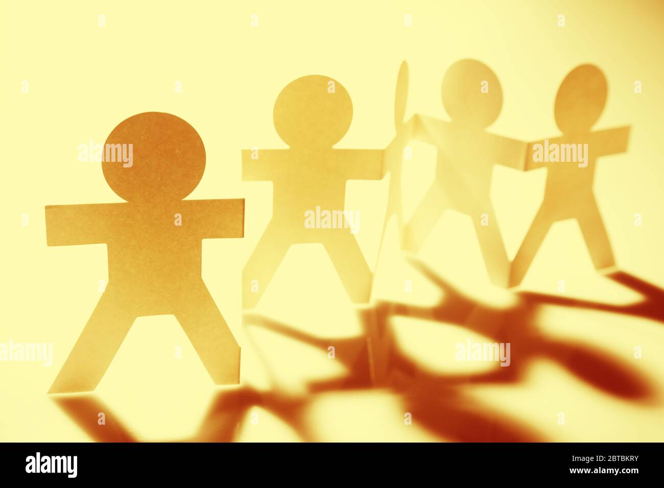 Paper chain team holding hands. Teamwork. Partnership Stock Photo - Alamy