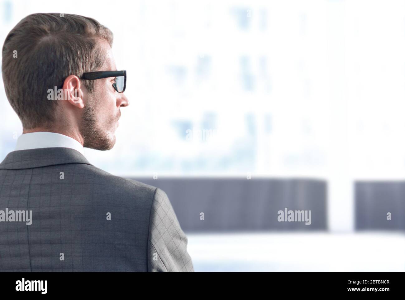 rear view.businessman standing near the office window Stock Photo - Alamy