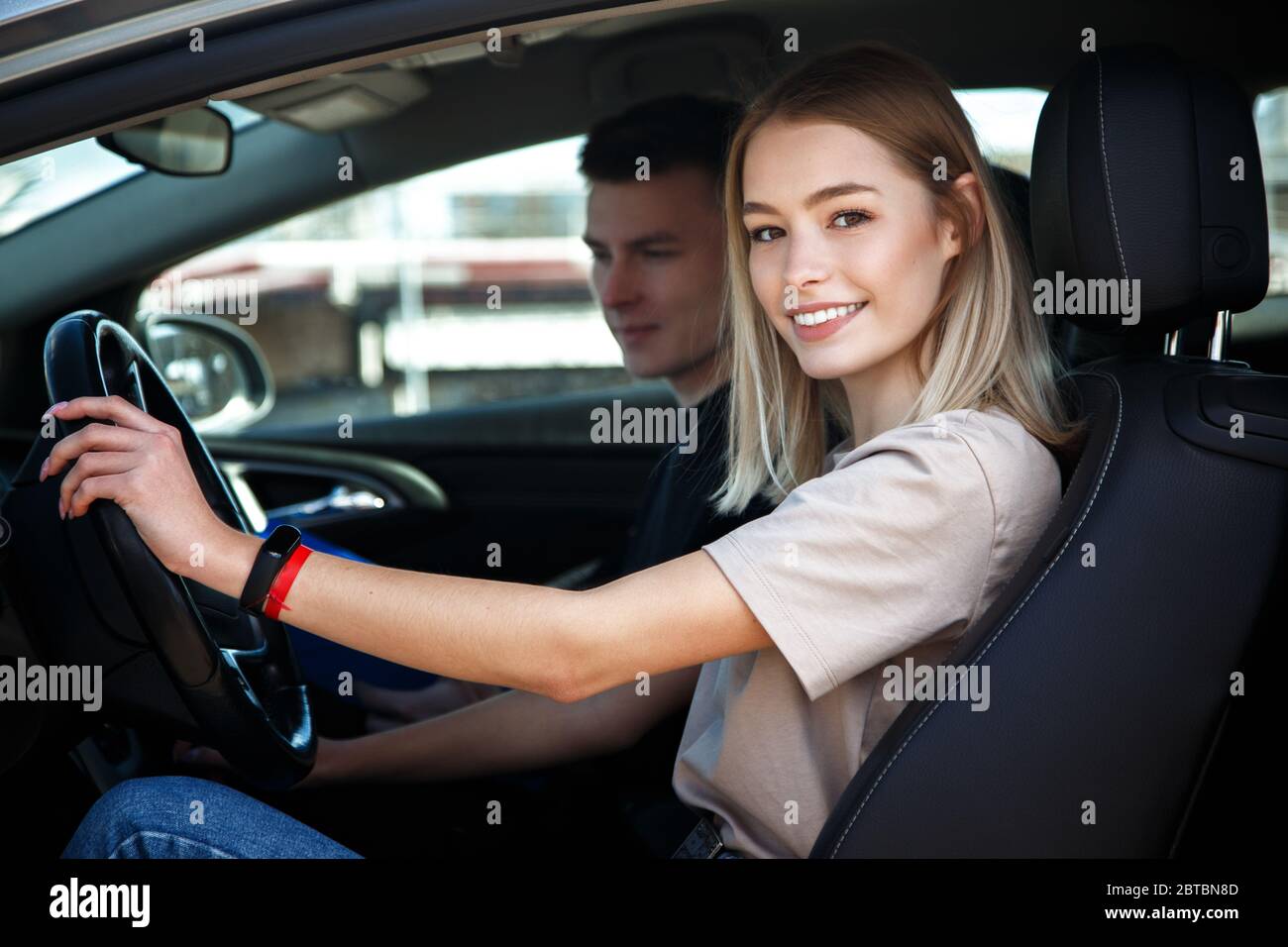 Driving instructor and woman student in examination car Stock Photo - Alamy
