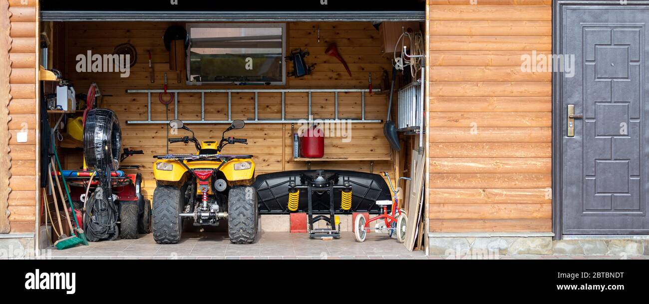 Facade front view open door ATV quad bike motorcycle parking messy ...