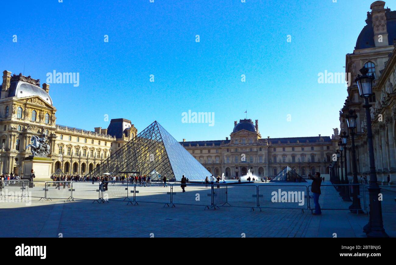 Side view of Louvre Museum with people around in the main square, Paris ...